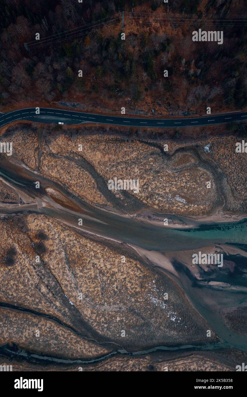 A vertical nature view of a blue crystal river under mountains from ...