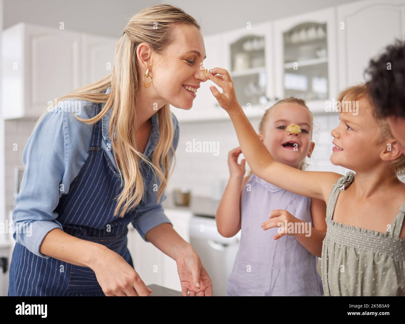 Family baking and mother teaching children to bake cake in the kitchen ...