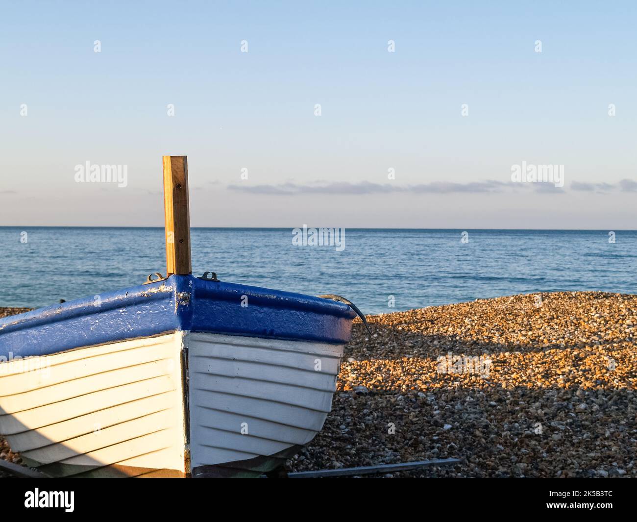 Blue and white boat on shore Stock Photo - Alamy