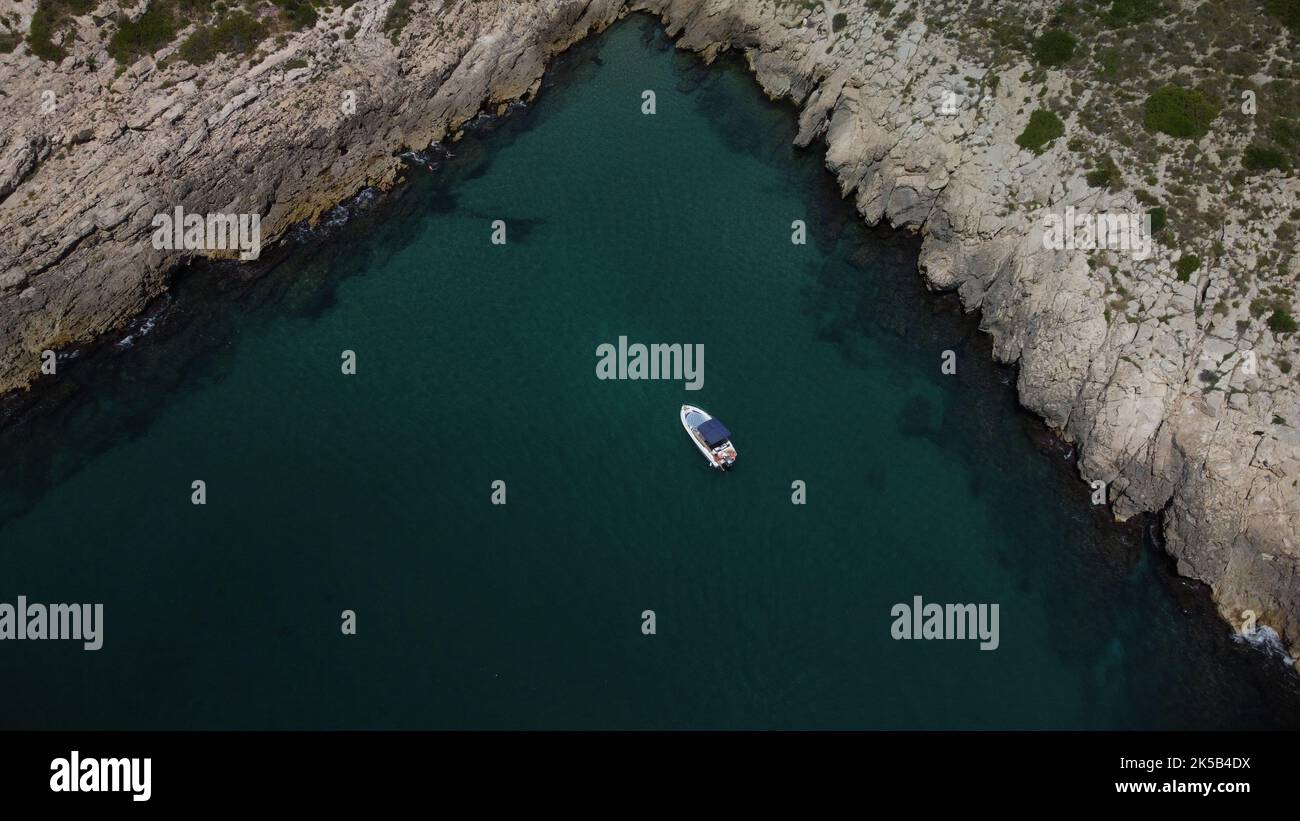An aerial view of boat floating on lake surrounded by cliffs Stock ...