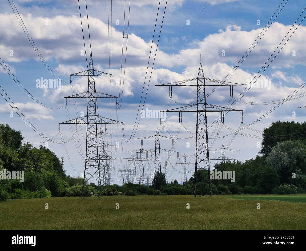 Two rows of electrical transmission towers on a field Stock Photo - Alamy