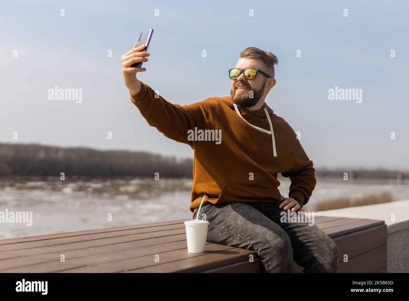 Excited young guy is making selfie on smartphone. He is gen Z or ...