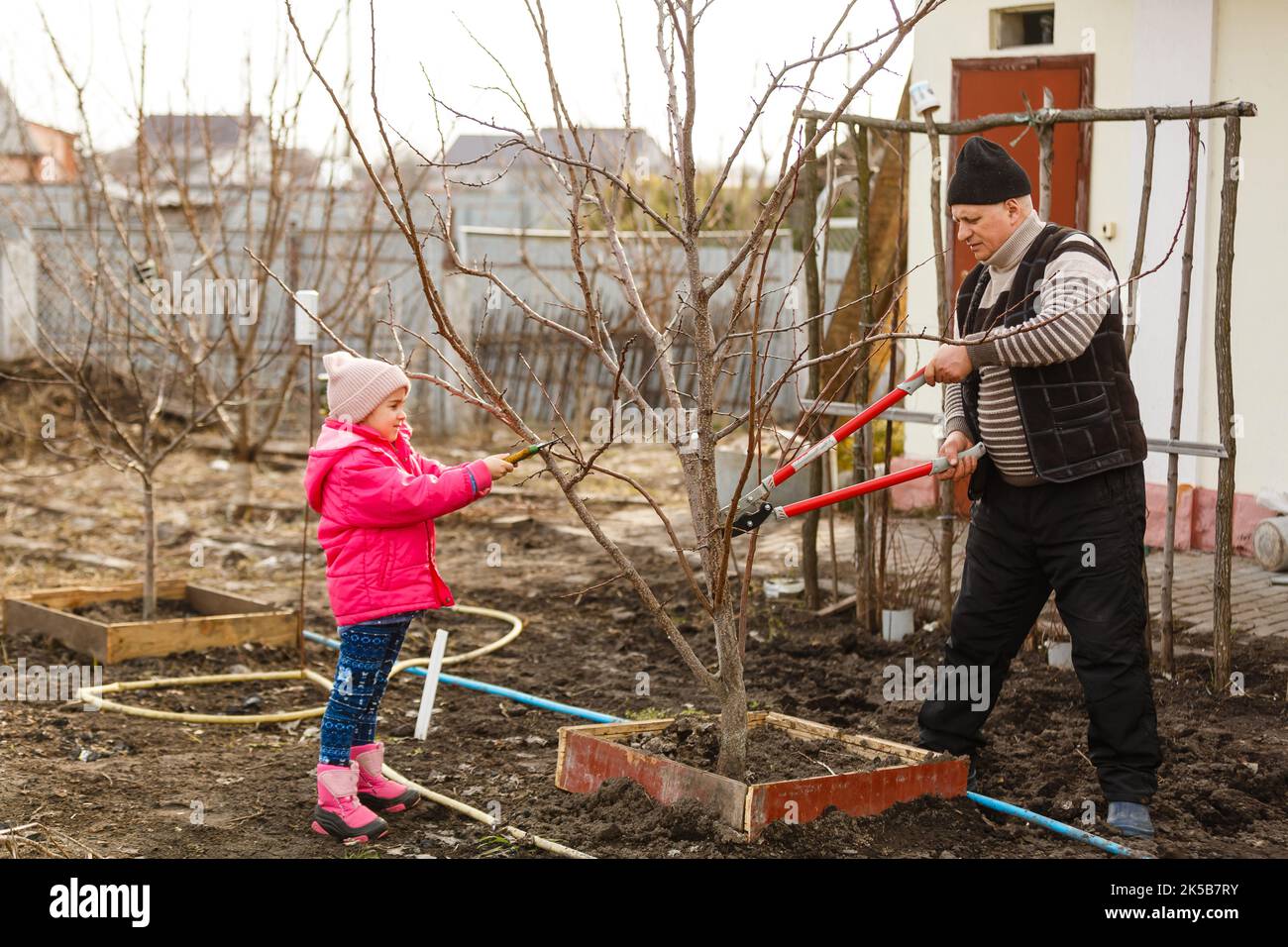 Smiling family members taking care of trees Stock Photo - Alamy