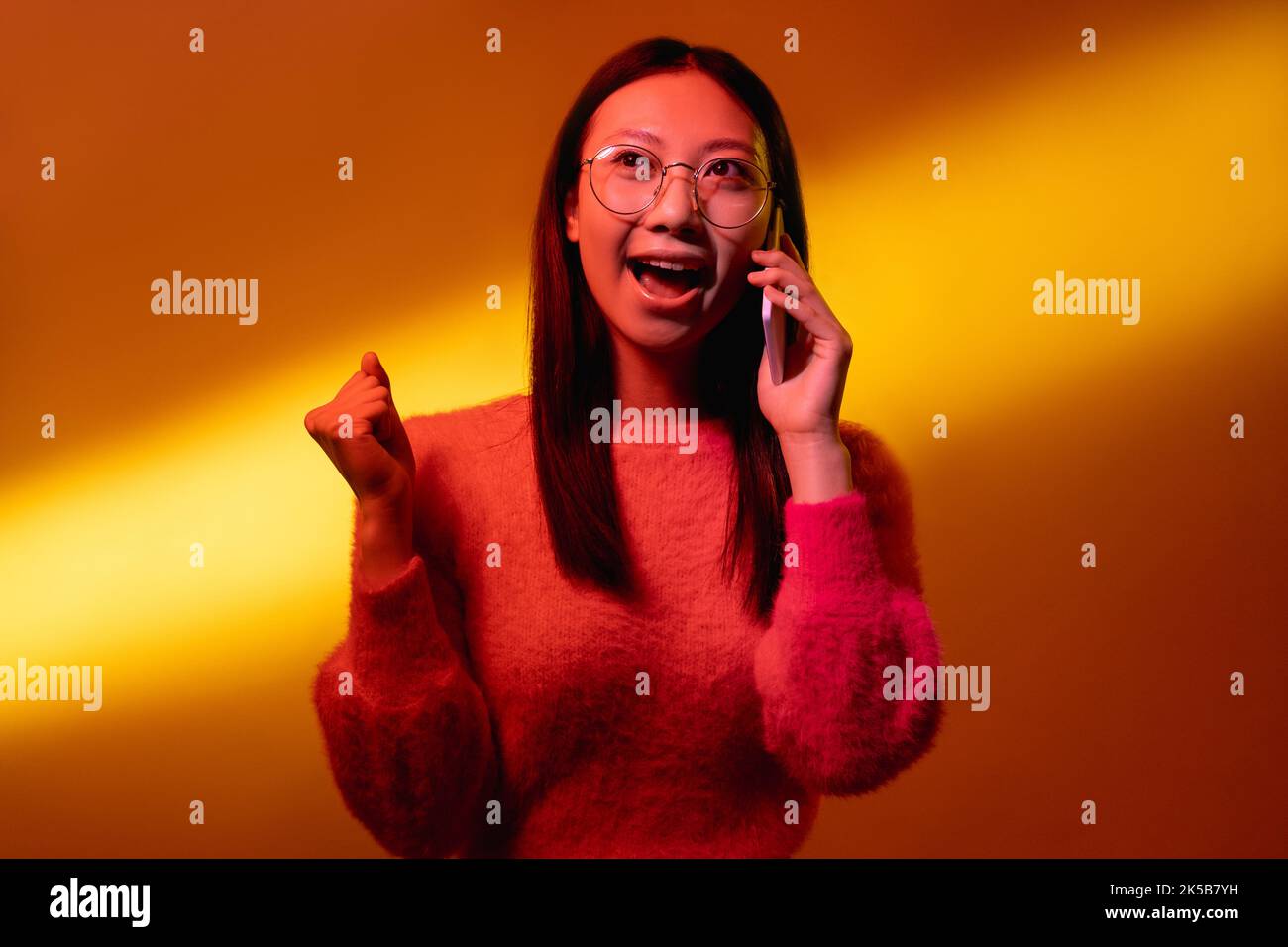 winner phone call neon light portrait excited girl Stock Photo - Alamy