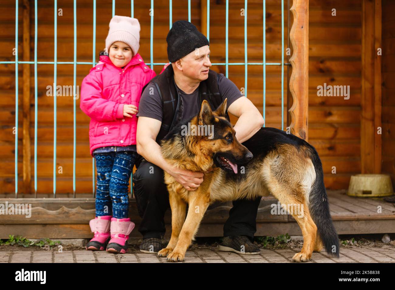 The man affects the dog, obedient and loving dog, captive dogs pull their heads through the bars ...