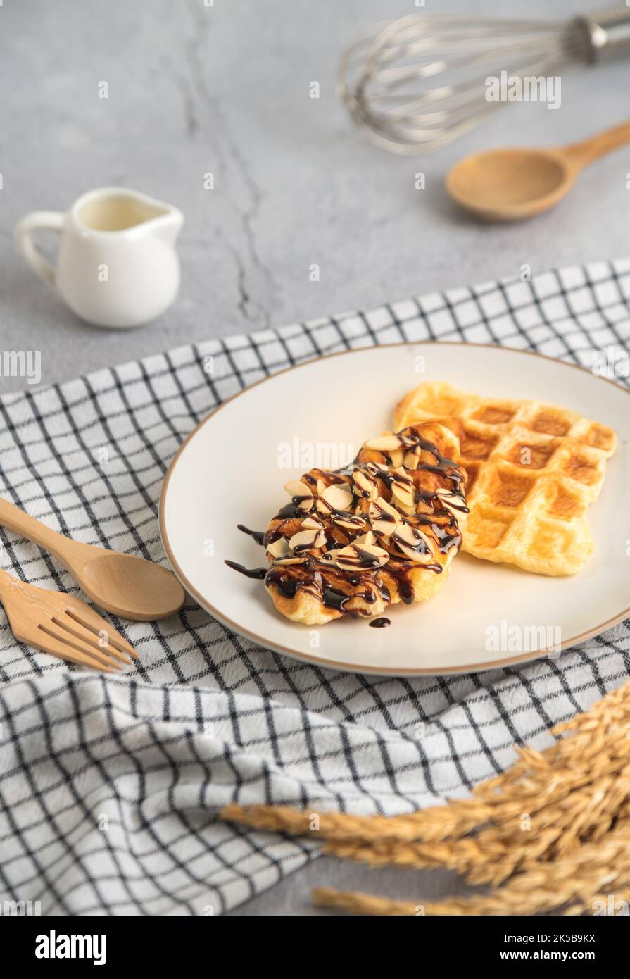 Croffles with almonds chocolate sauce topping and caramel on plate ...