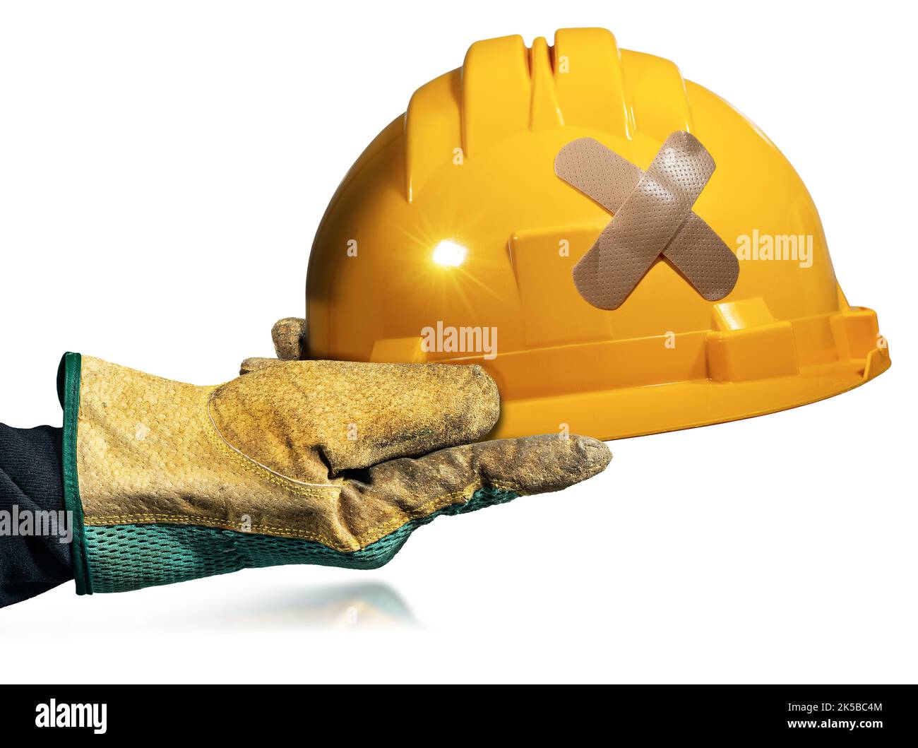 Manual worker with protective work glove holding a yellow safety helmet ...