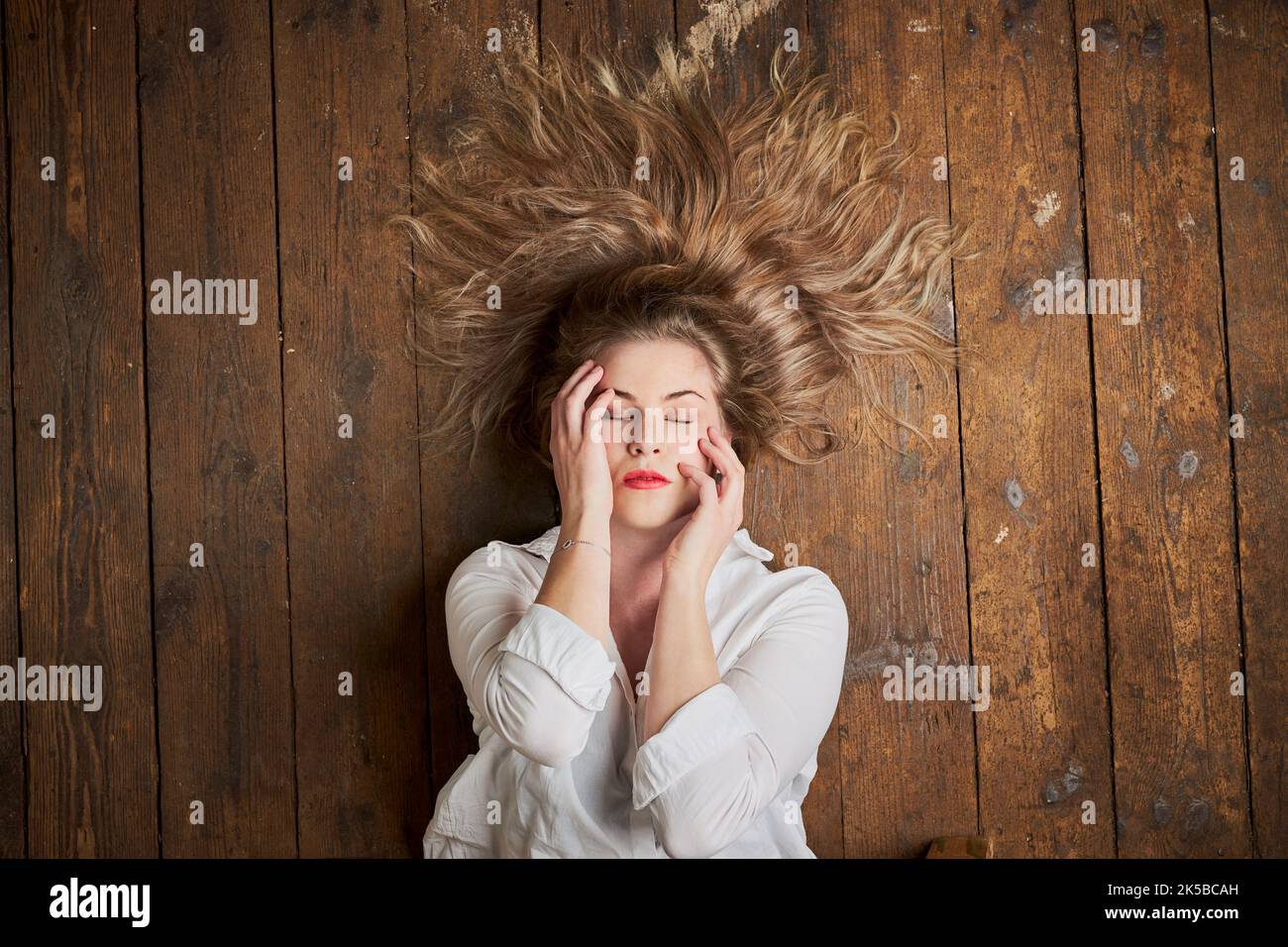 Female model laying down on wood floor Stock Photo - Alamy