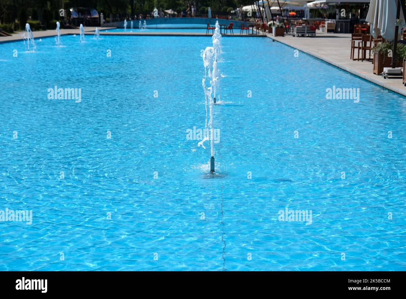 Vertical water streams of fountain, blue water. Streams flowing out of ...