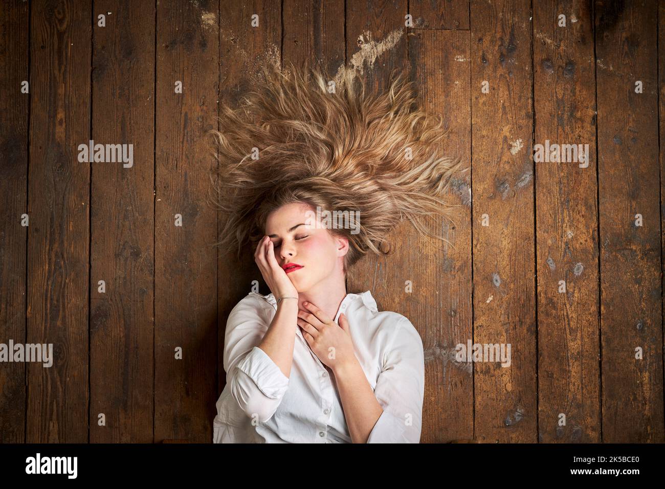 Female model laying down on wood floor Stock Photo - Alamy