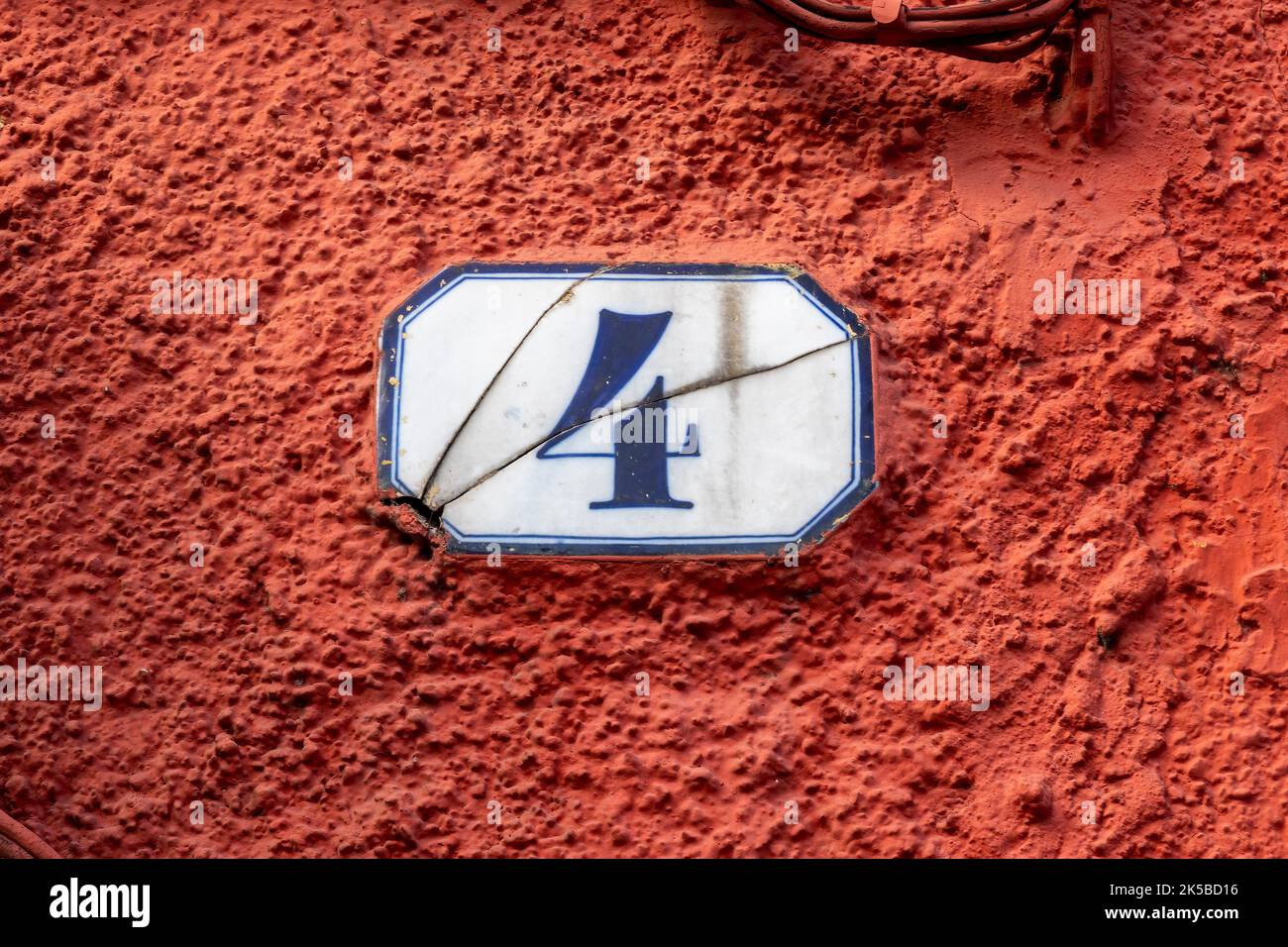 Number four door number on enamel plate on plaster wall Stock Photo - Alamy