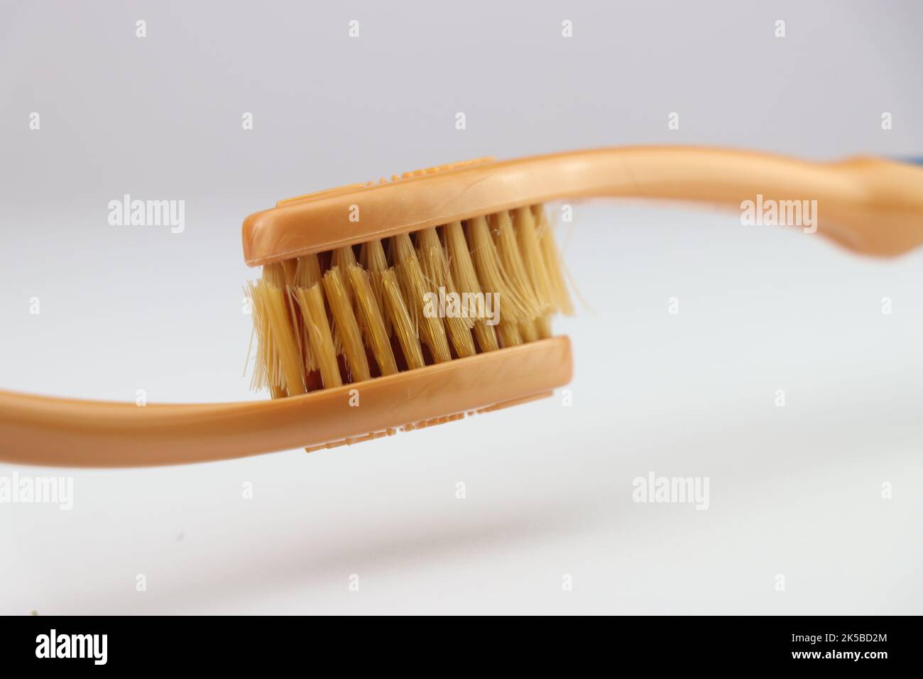 Two toothbrush attached on top of one another on a white background ...