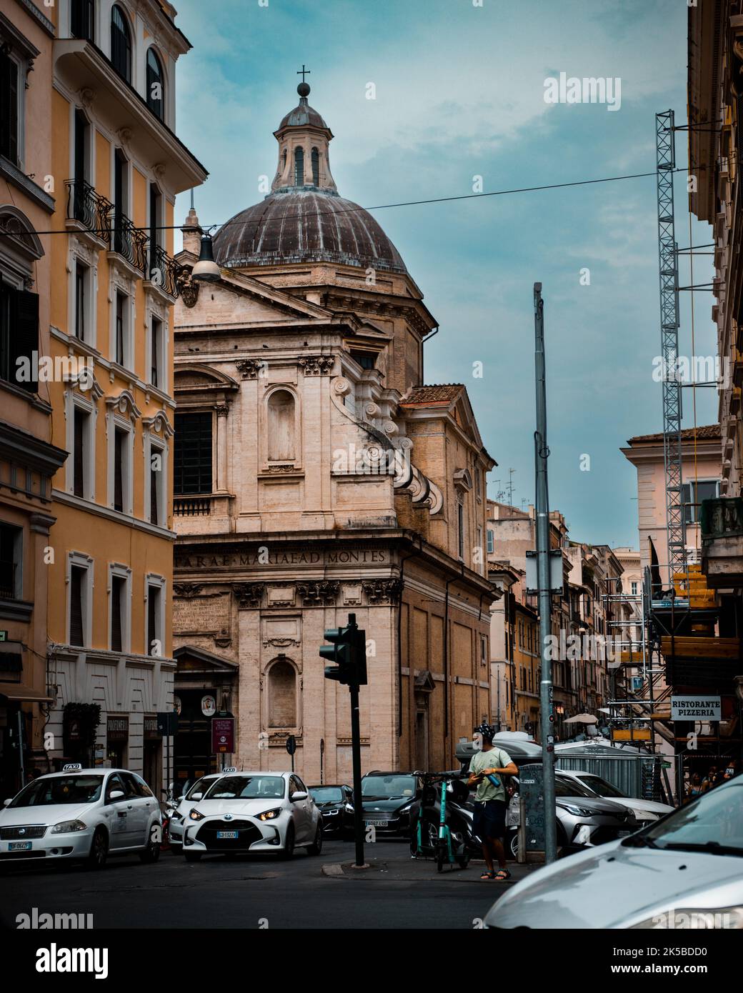 A vertical low-angle of street in Rome with cars and Piazza del Popolo ...