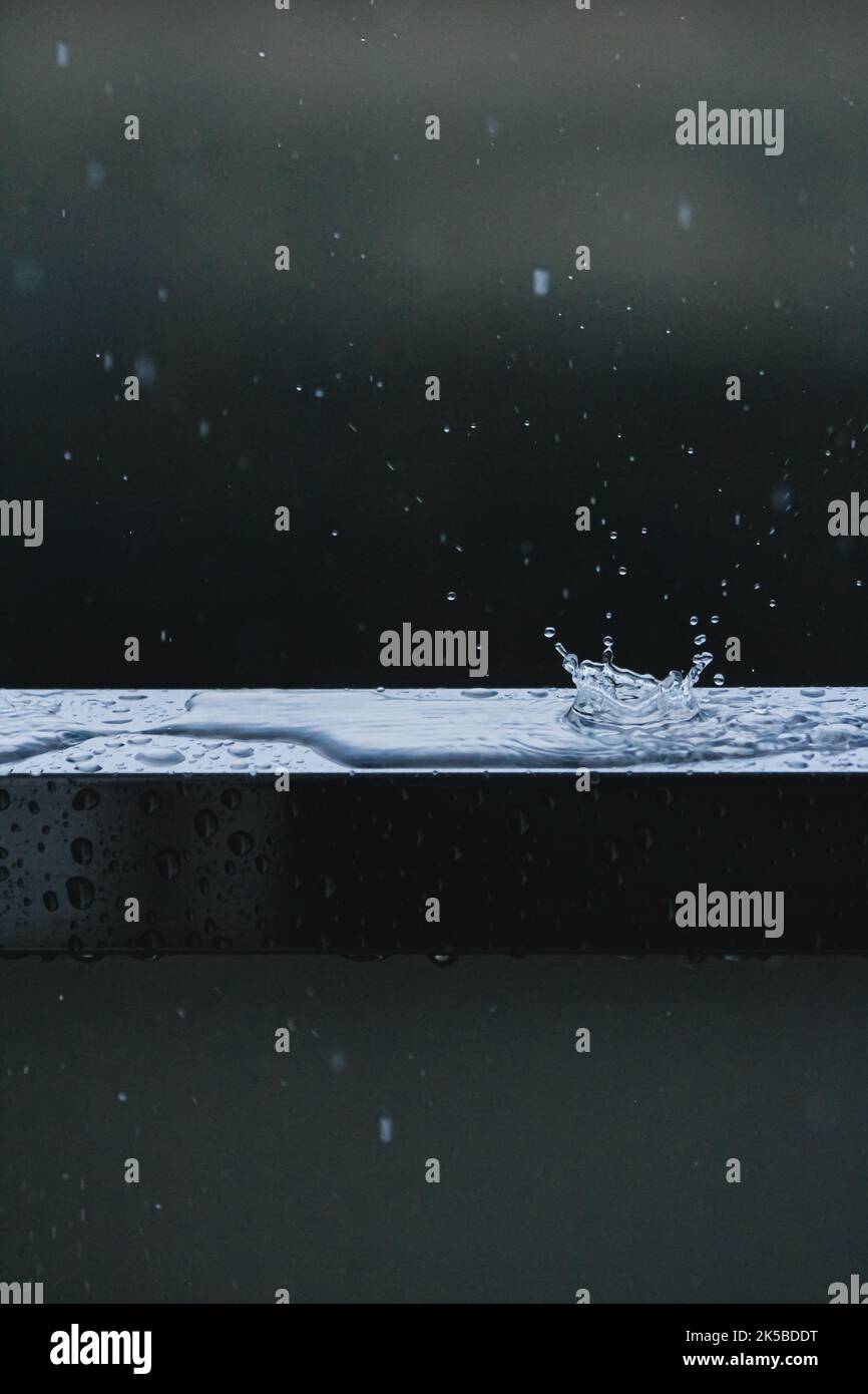 A vertical of dark background with water drops and a water line ...