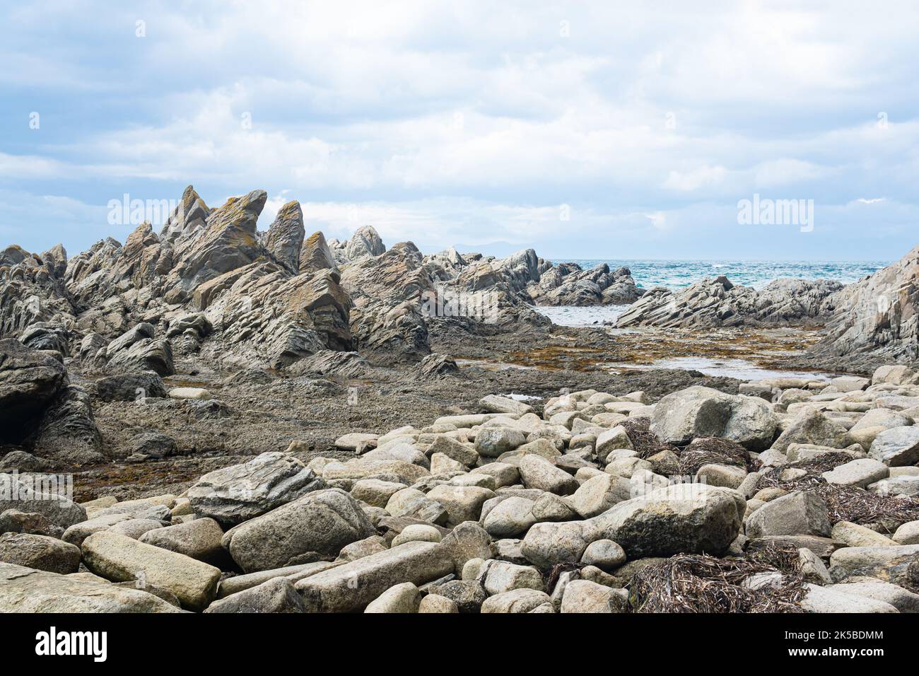 sharp jagged basalt rocks on the sea coast, Cape Stolbchaty on Kunashir ...