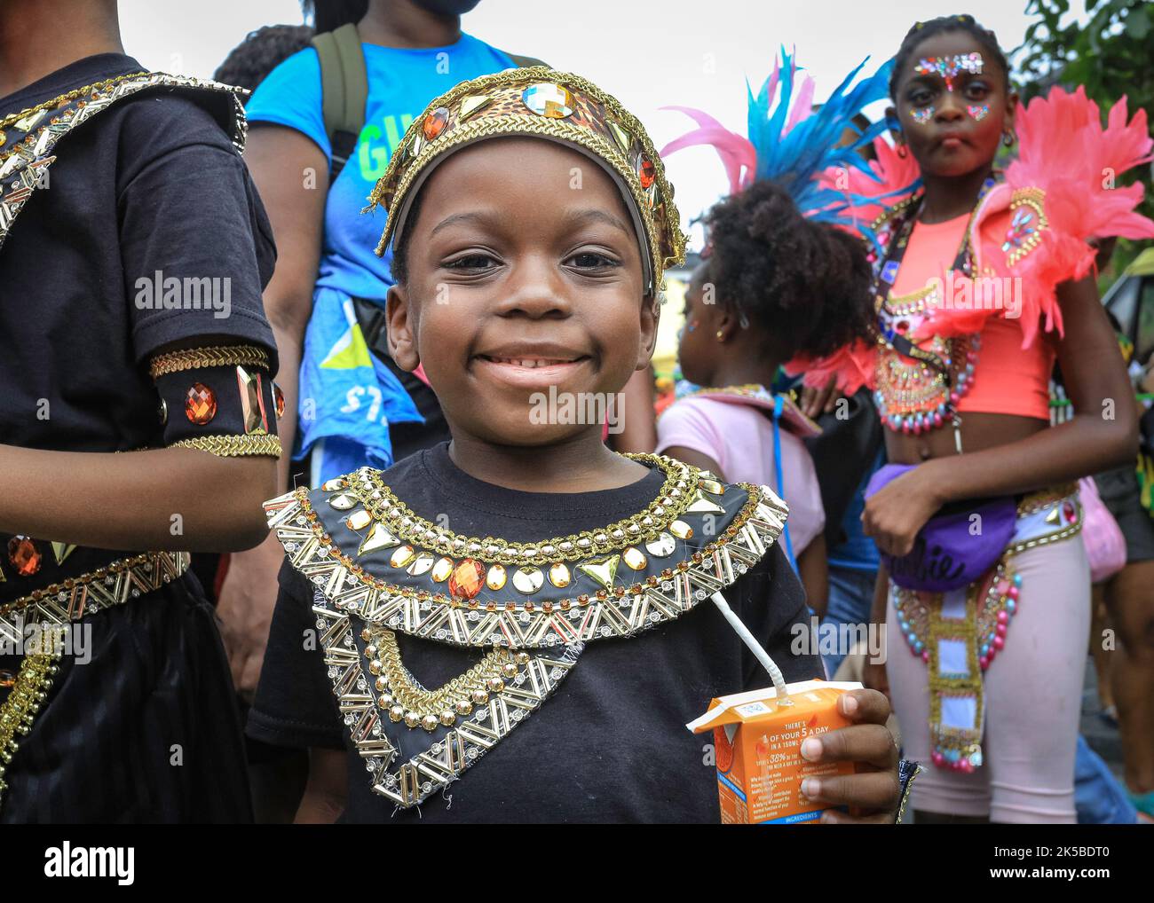 A little boy smiles as children participate in the family day parade at ...