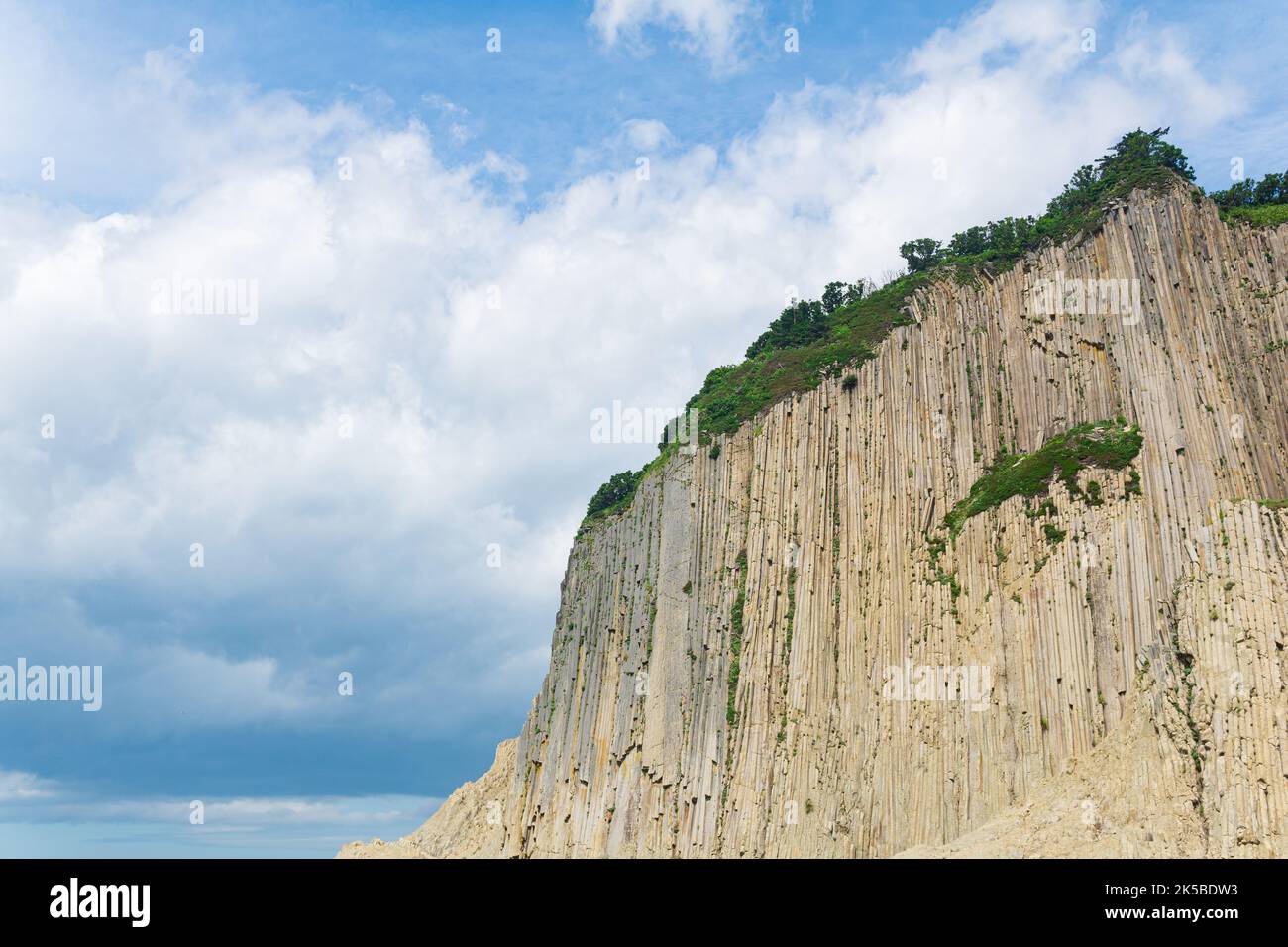 top of columnar volcanic basalt cliff against the background of the sky ...