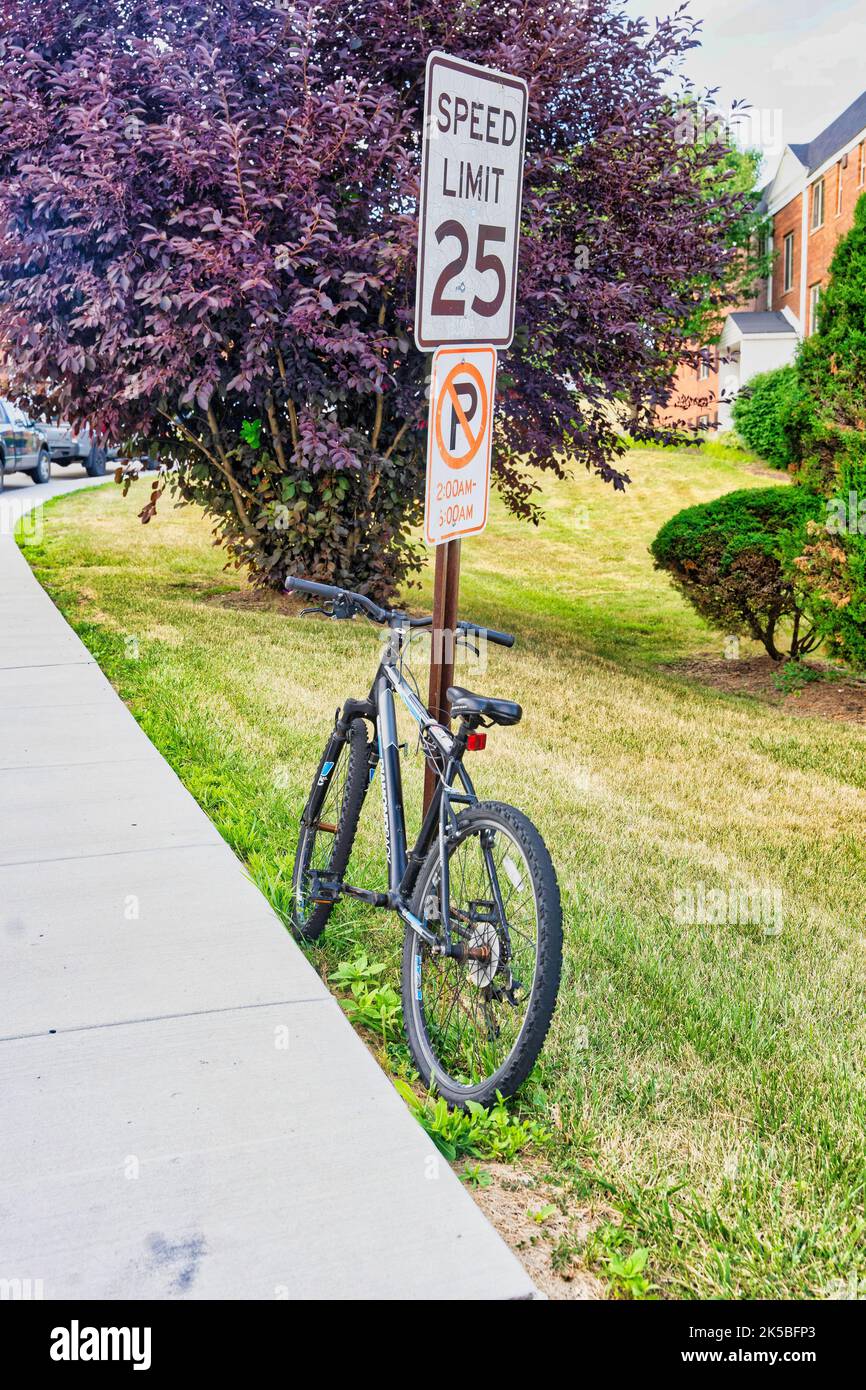 A vertical shot of a speed limit sign with bike chained to it Stock Photo - Alamy