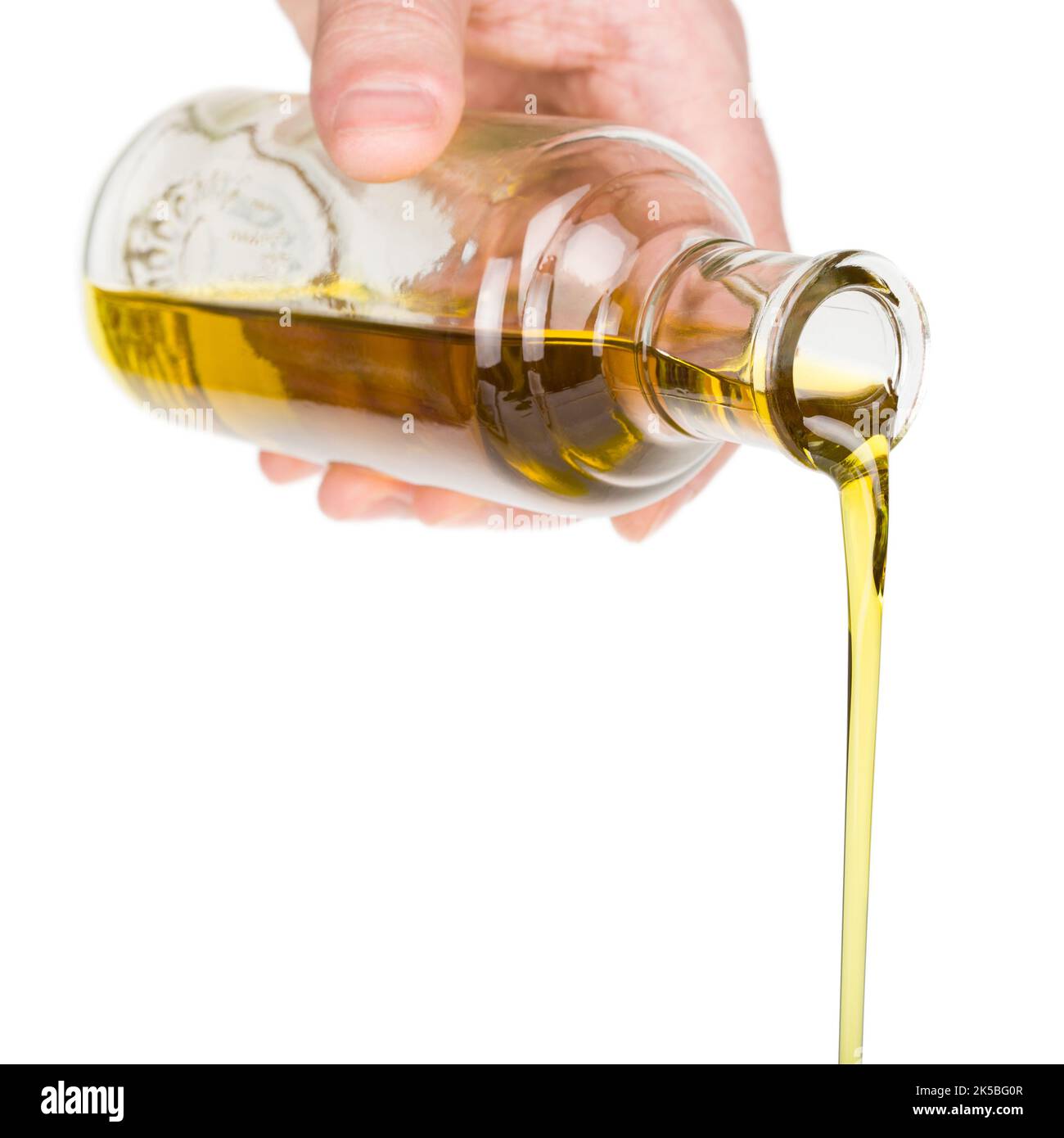 Male hand holding a bottle. Oil pouring from a bottle Stock Photo - Alamy