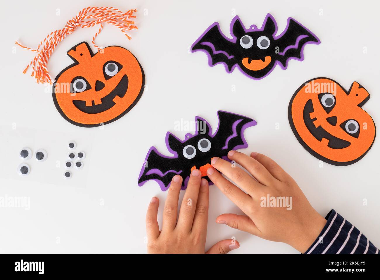 child making felt halloween decorations with spooky face Stock Photo ...