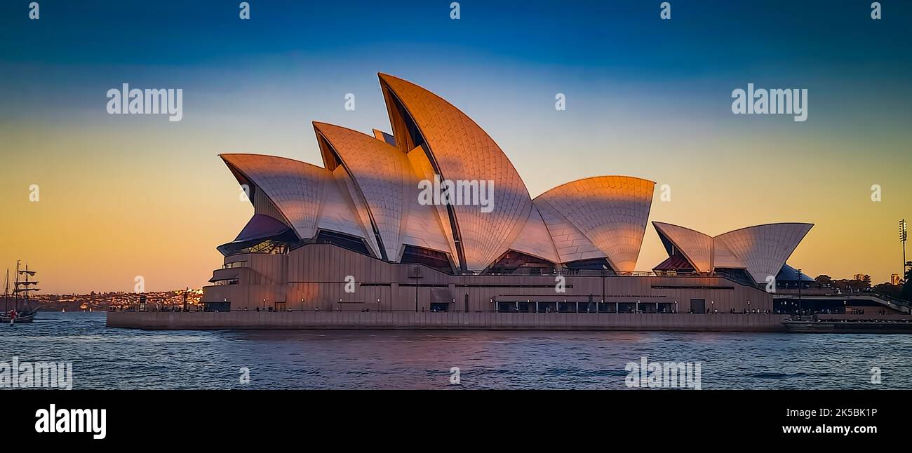 The beautiful Sydney Opera House at sunset shadowed by Sydney Harbor ...