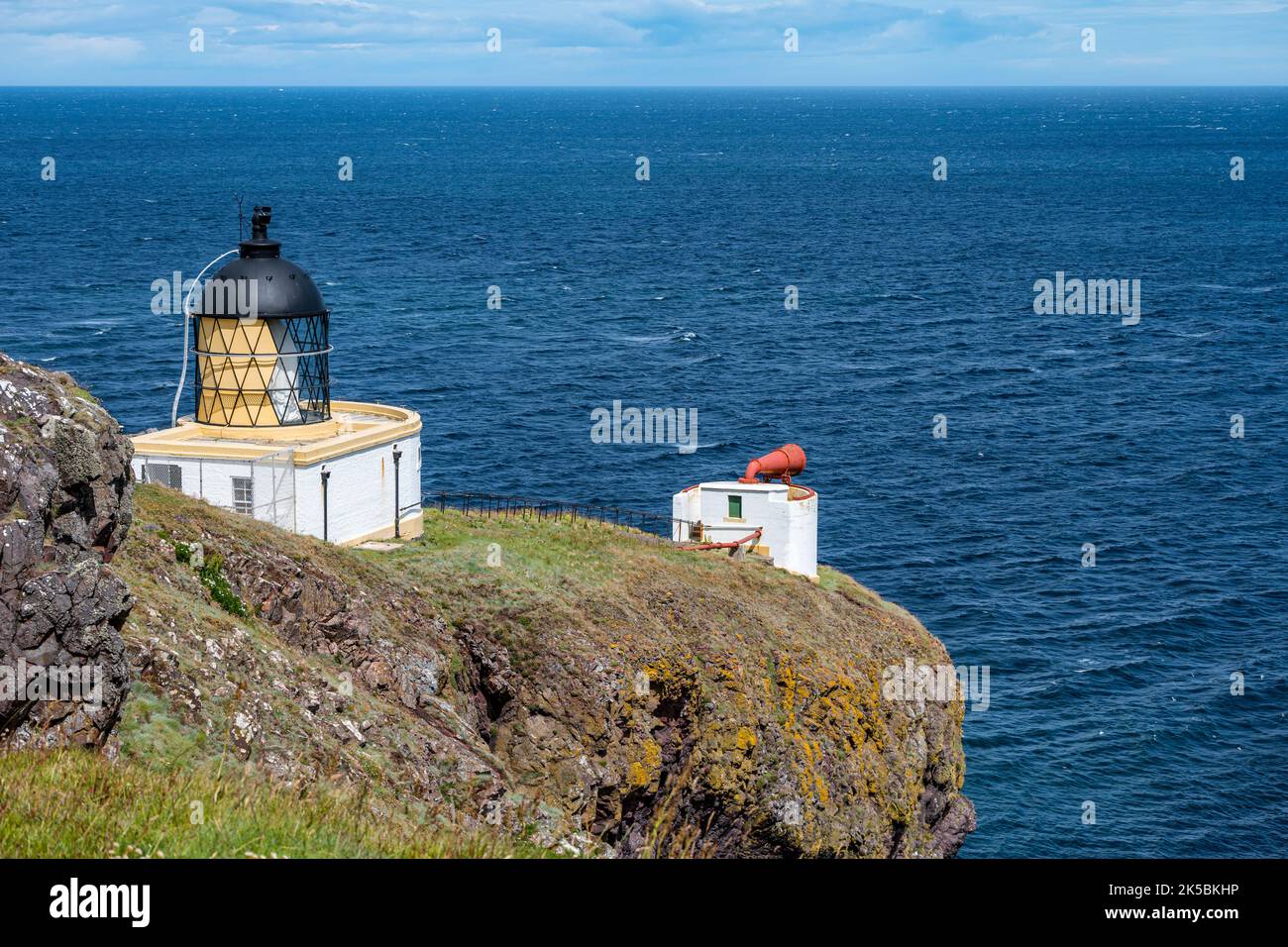 St Abb's Head lighthouse on headland cliff with foghorn on cliff over the North Sea ...