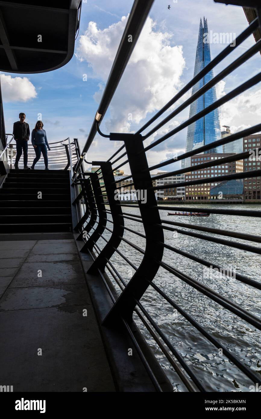 Visitors walking down steps of London Bridge with the Thames and the ...