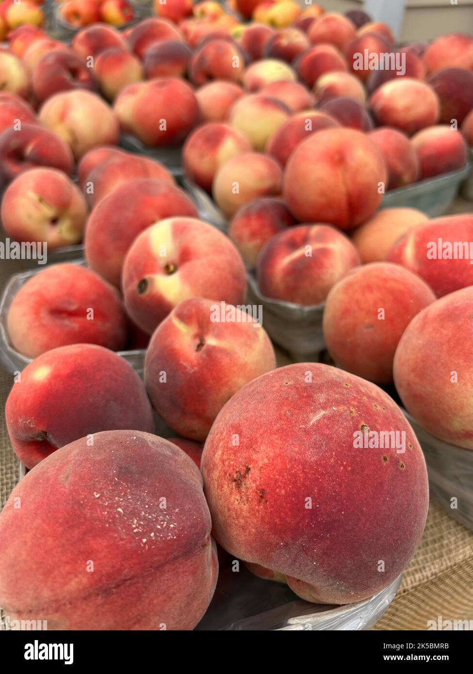 Baskets of freshly harvested peaches for sale at a roadside farm stand ...
