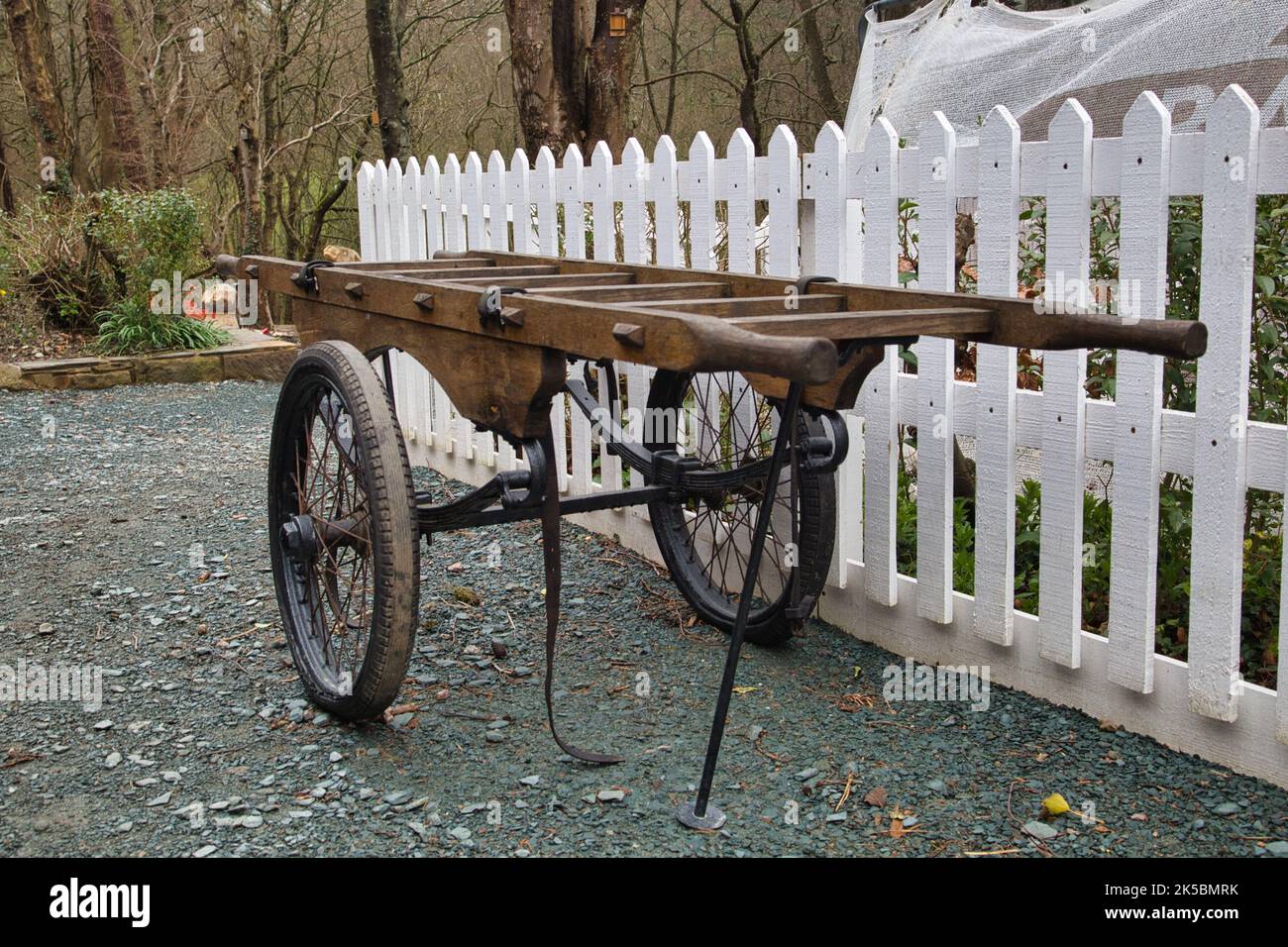 A vintage baggage trolley next to a white fence Stock Photo - Alamy