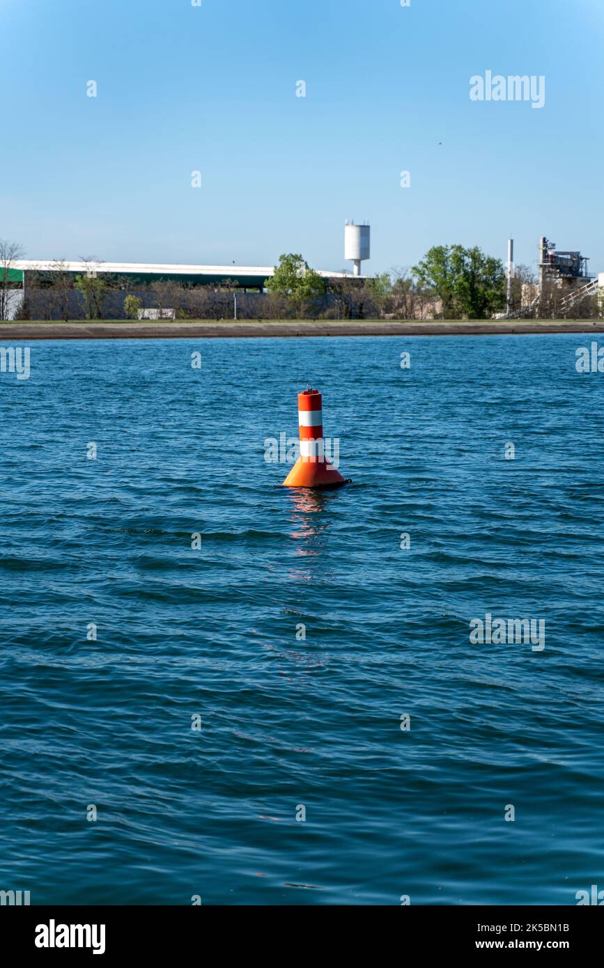 A vertical shot of a buoy floating on the surface of a lake in the ...