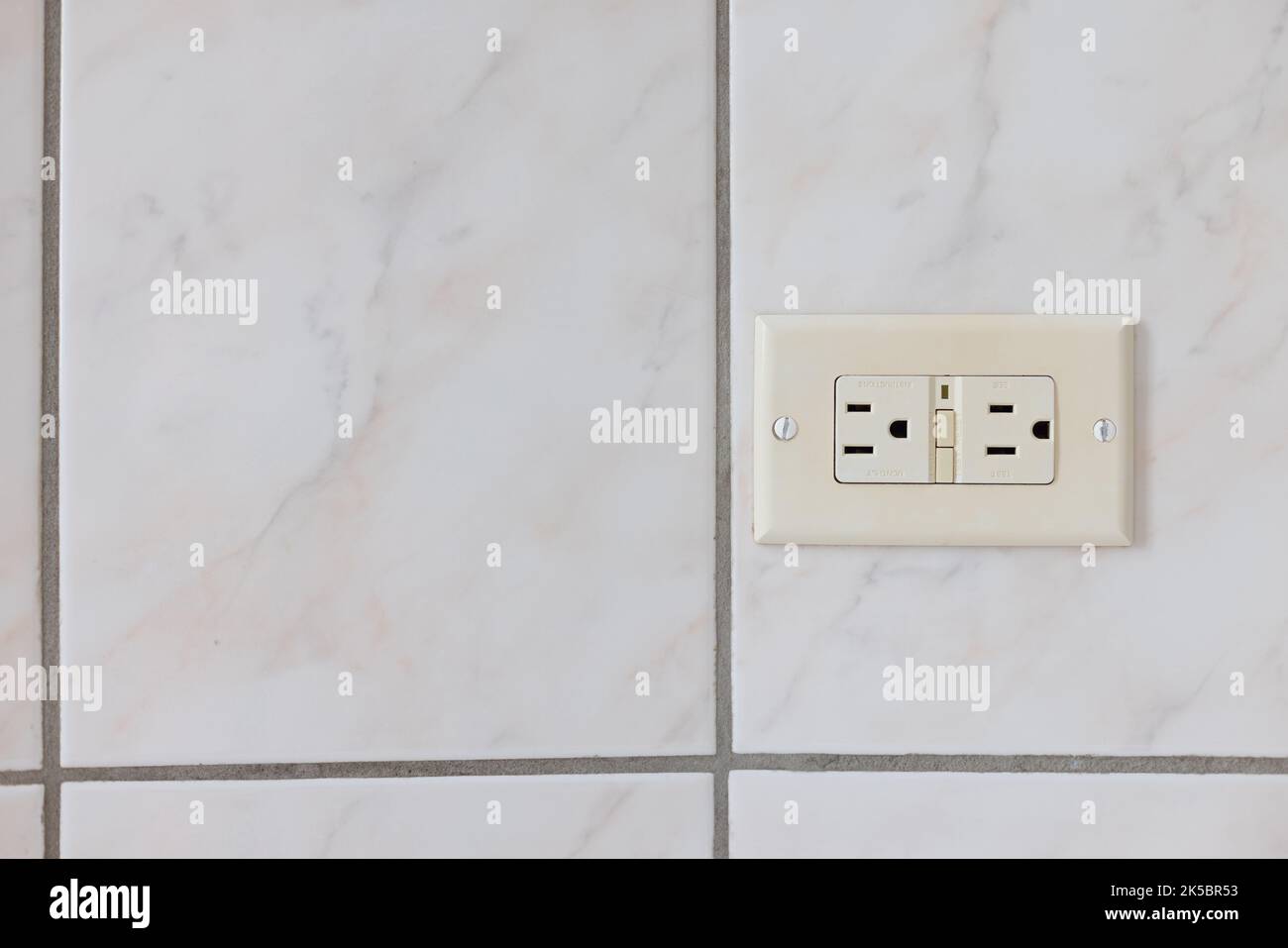 Electrical plug type B on the tiled wall in a bathroom Stock Photo - Alamy