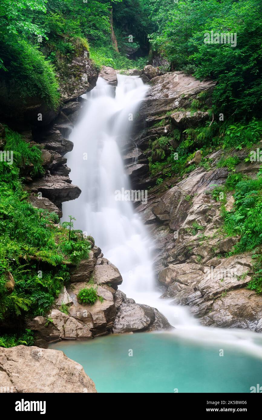 Waterfall cascade on mountain rocks. A mountain waterfall flows over ...