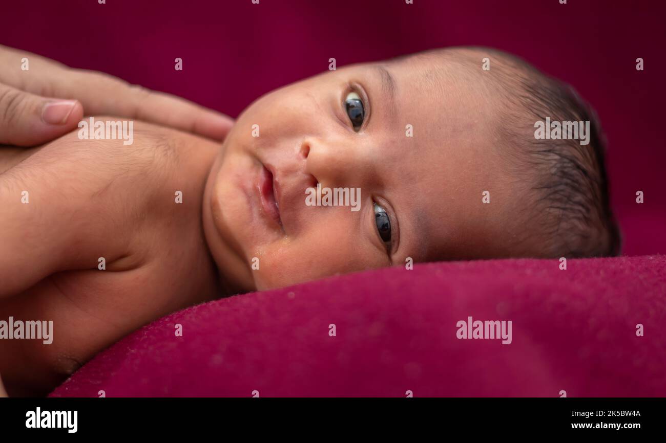 newly born baby with mother touch laying on red velvet cloth with cute ...