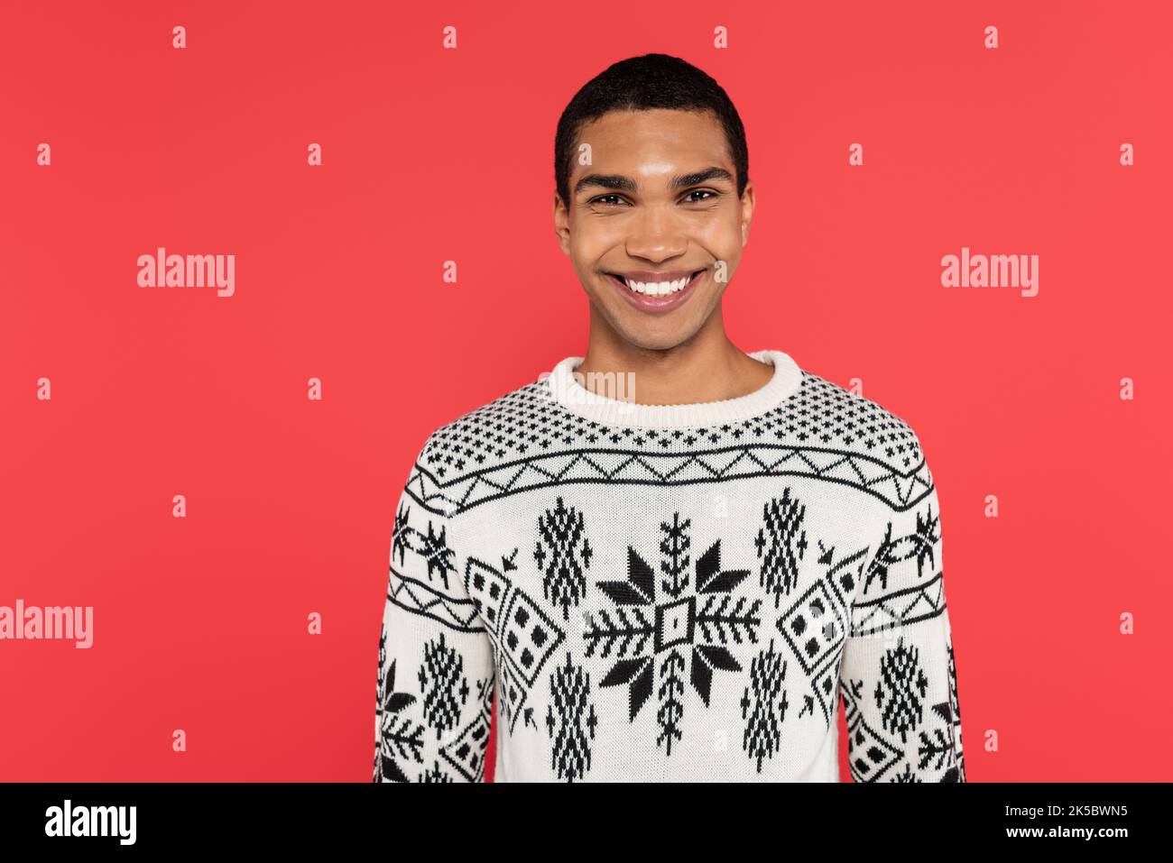 front view of happy african american man in knitted sweater with winter ...