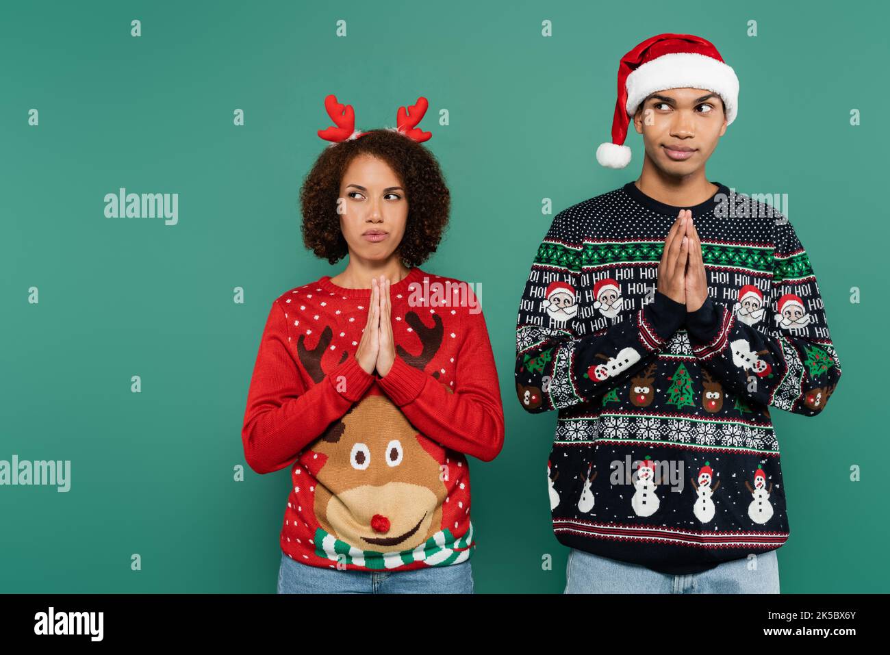 tense african american couple in christmas outfit standing with praying ...