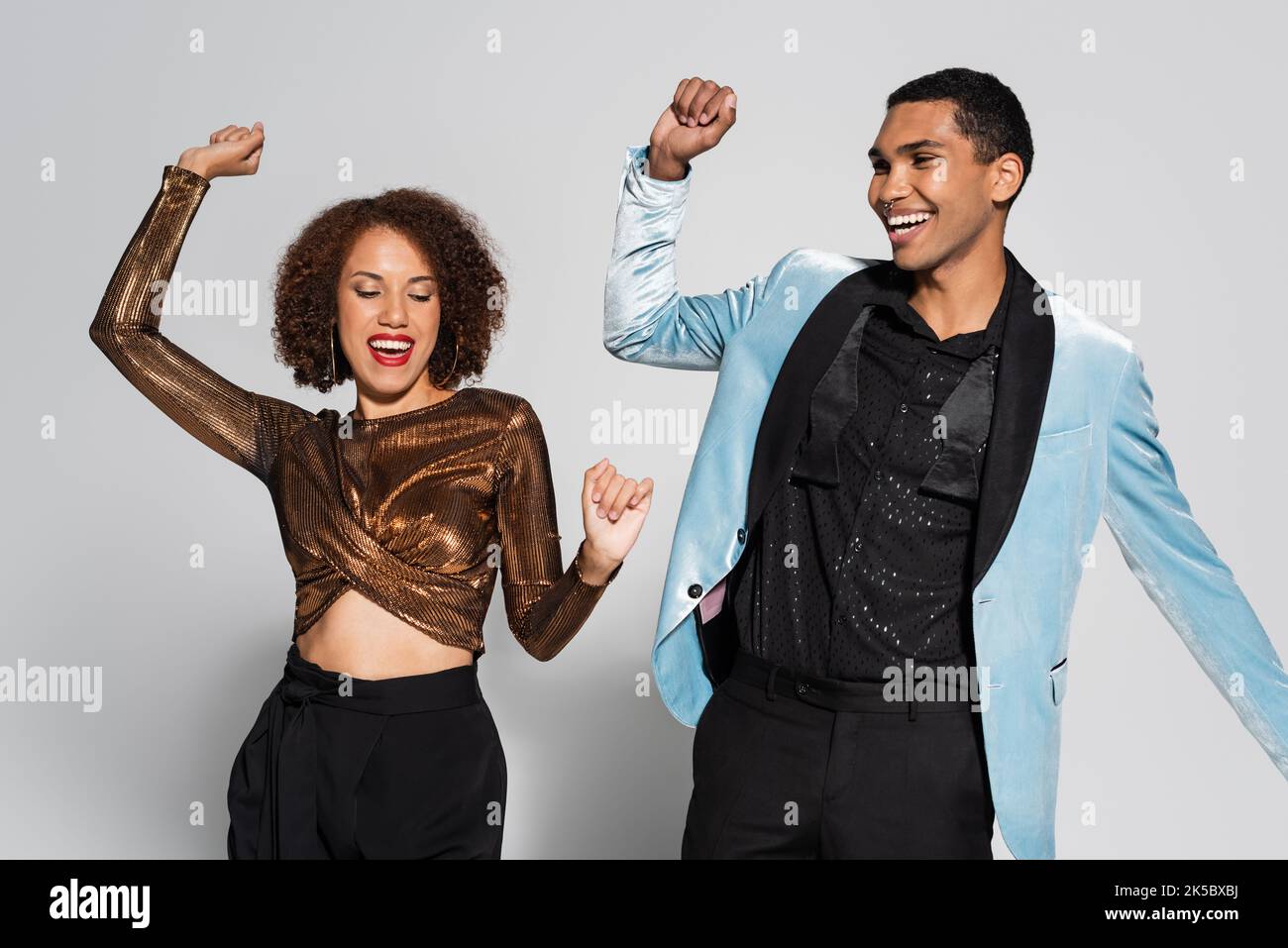 excited african american couple in elegant clothes dancing on christmas ...