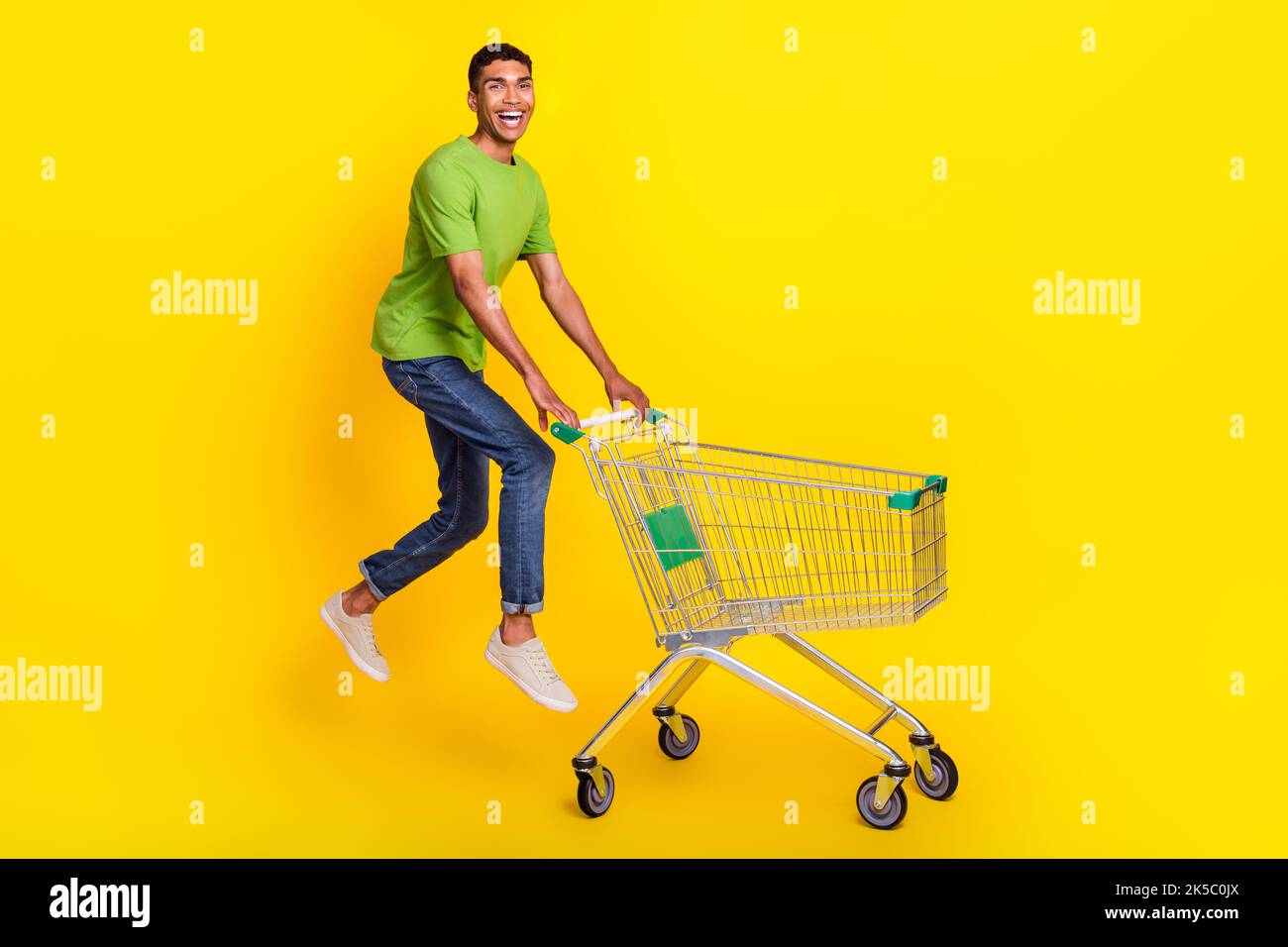 Full length photo of funny cheerful guy wear green t-shirt walking tray ...
