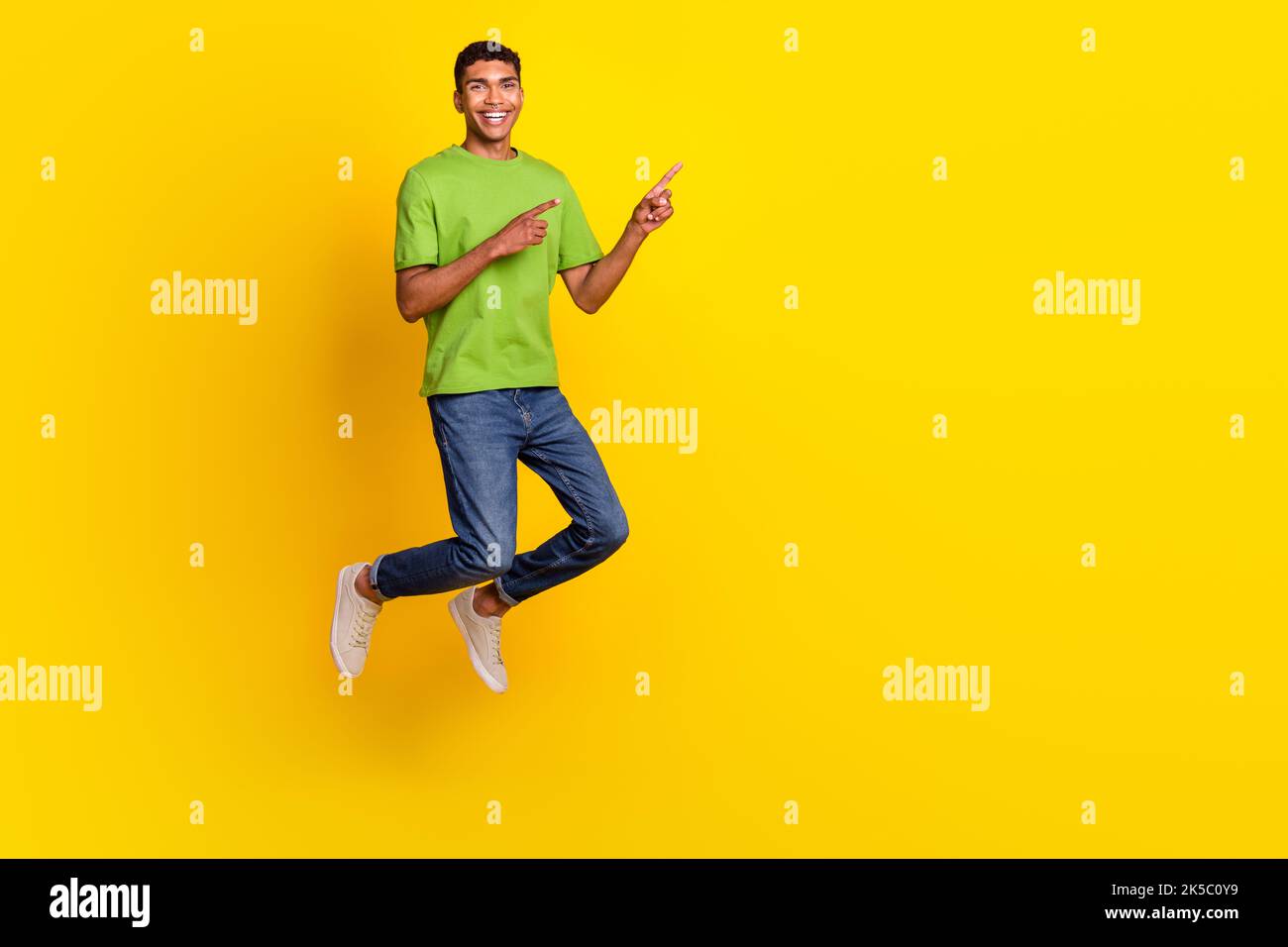 Full length portrait of active cheerful person jumping indicate fingers ...