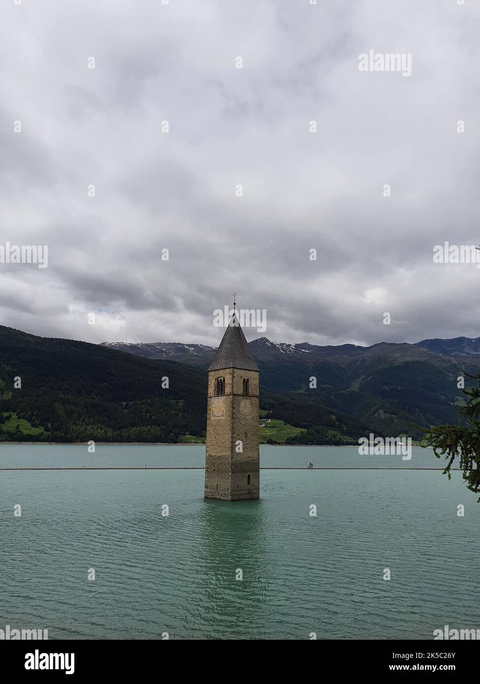 the bell tower of Curon submerged in Lake Resia in the Vinschgau Valley ...
