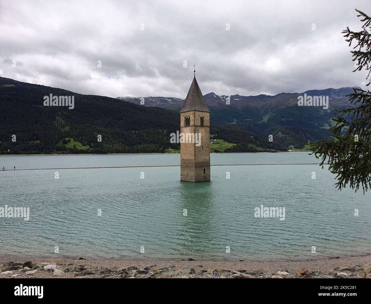 the bell tower of Curon submerged in Lake Resia in the Vinschgau Valley ...