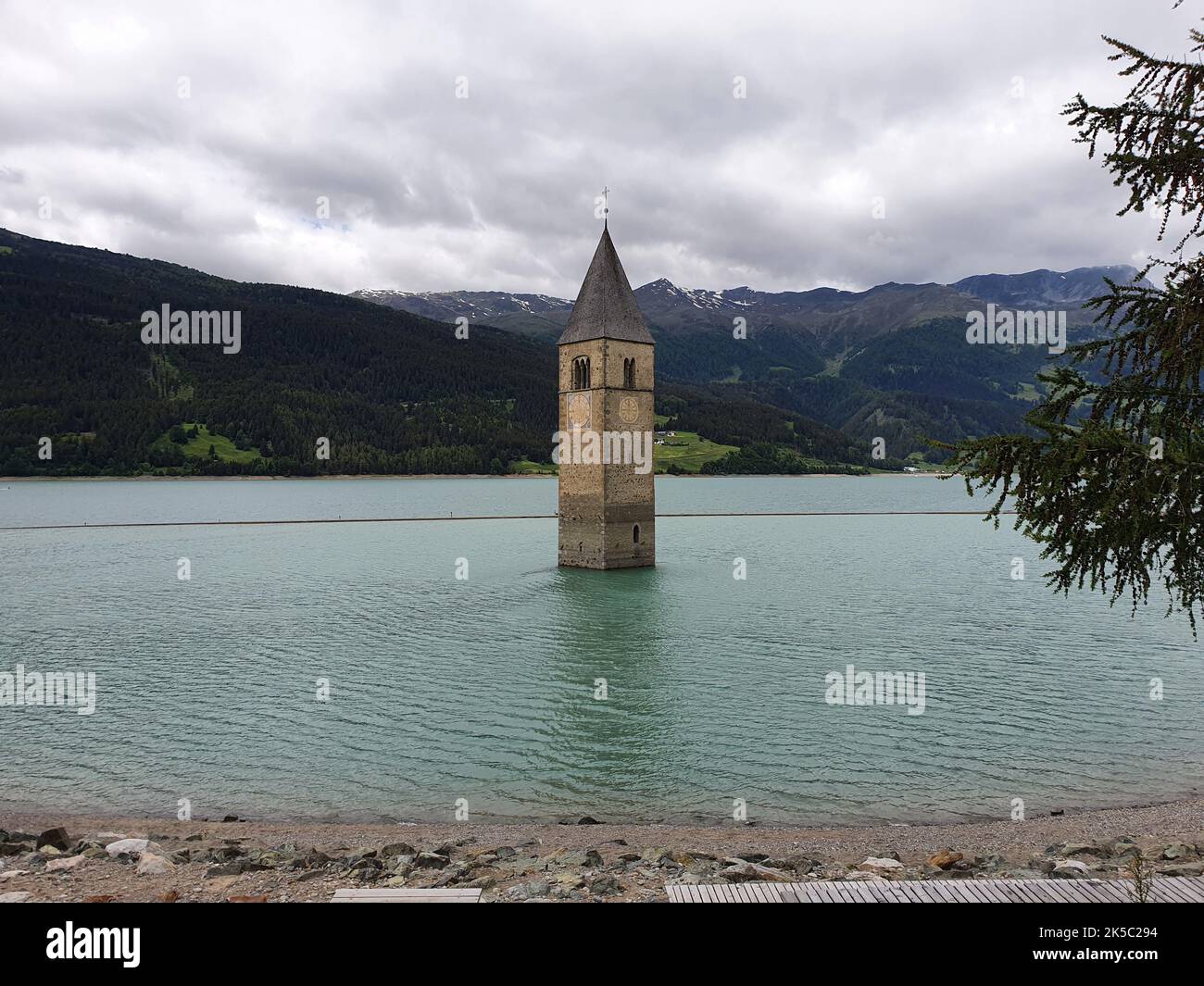 the bell tower of Curon submerged in Lake Resia in the Vinschgau Valley ...