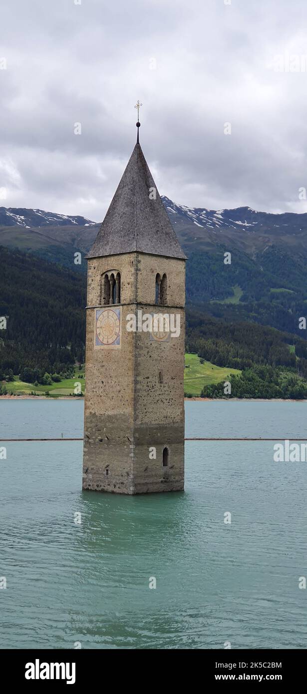 the bell tower of Curon submerged in Lake Resia in the Vinschgau Valley ...
