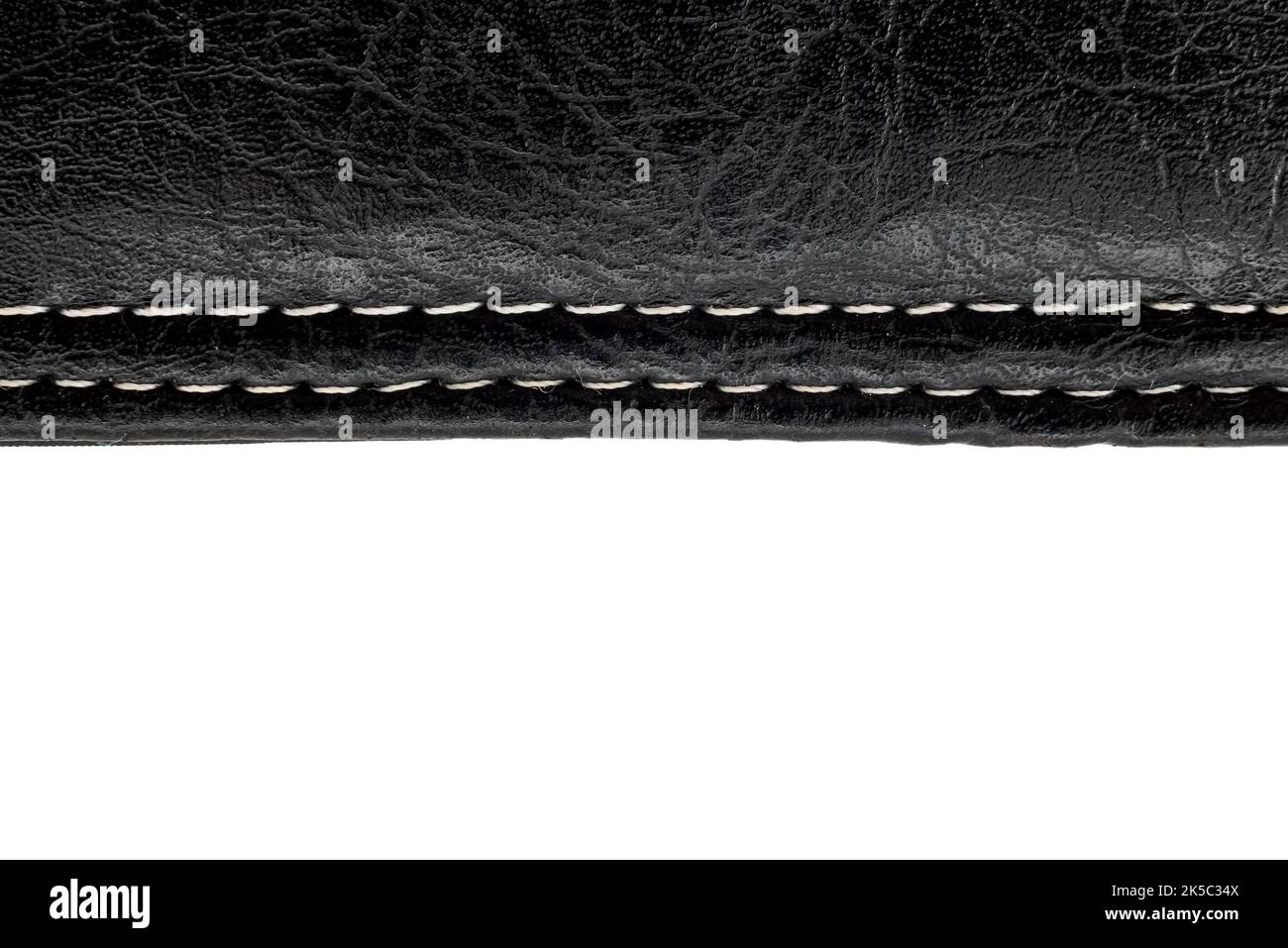 A piece of leather stitched with threads on a white background with ...