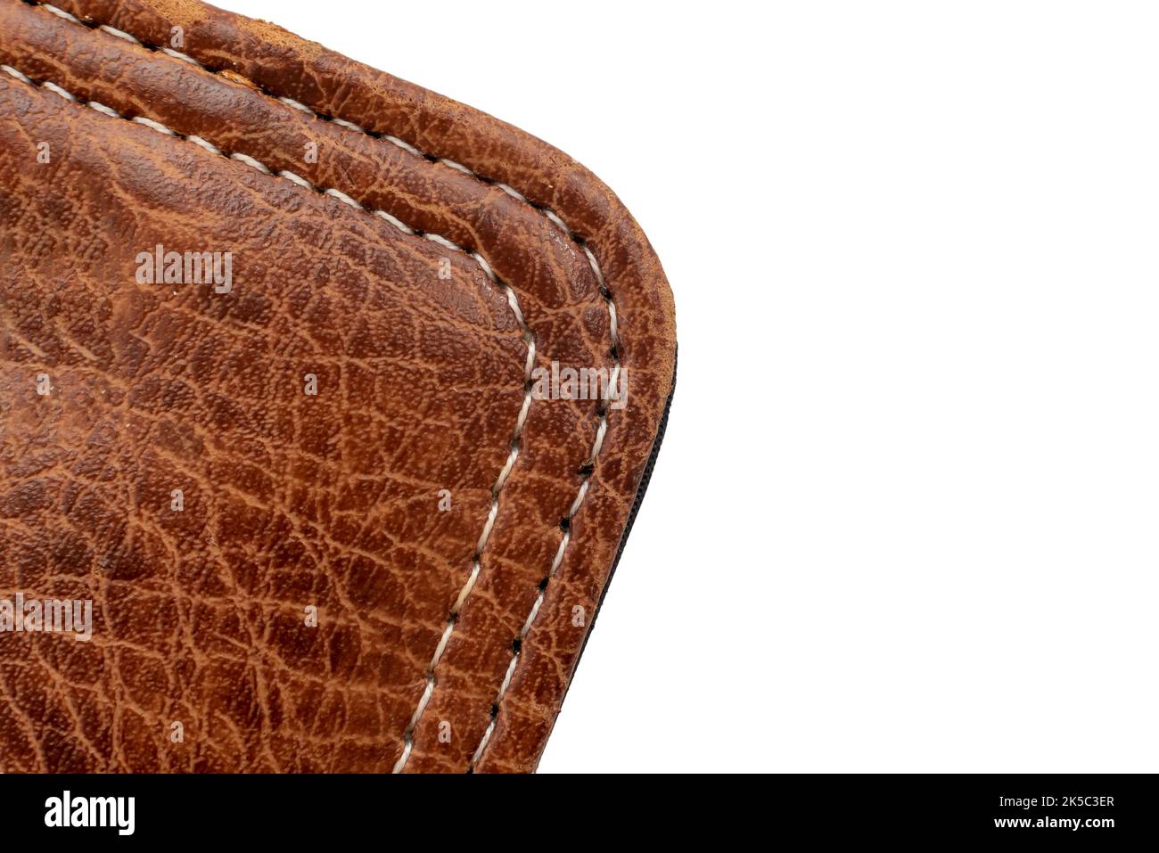 A piece of leather stitched with threads on a white background with ...