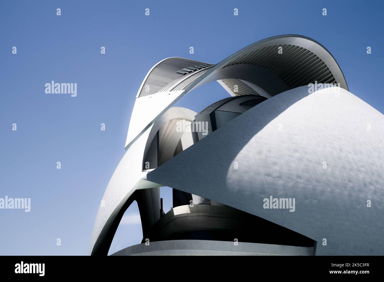 An exterior of Queen Sofia Palace of the Arts against a sunny blue sky ...