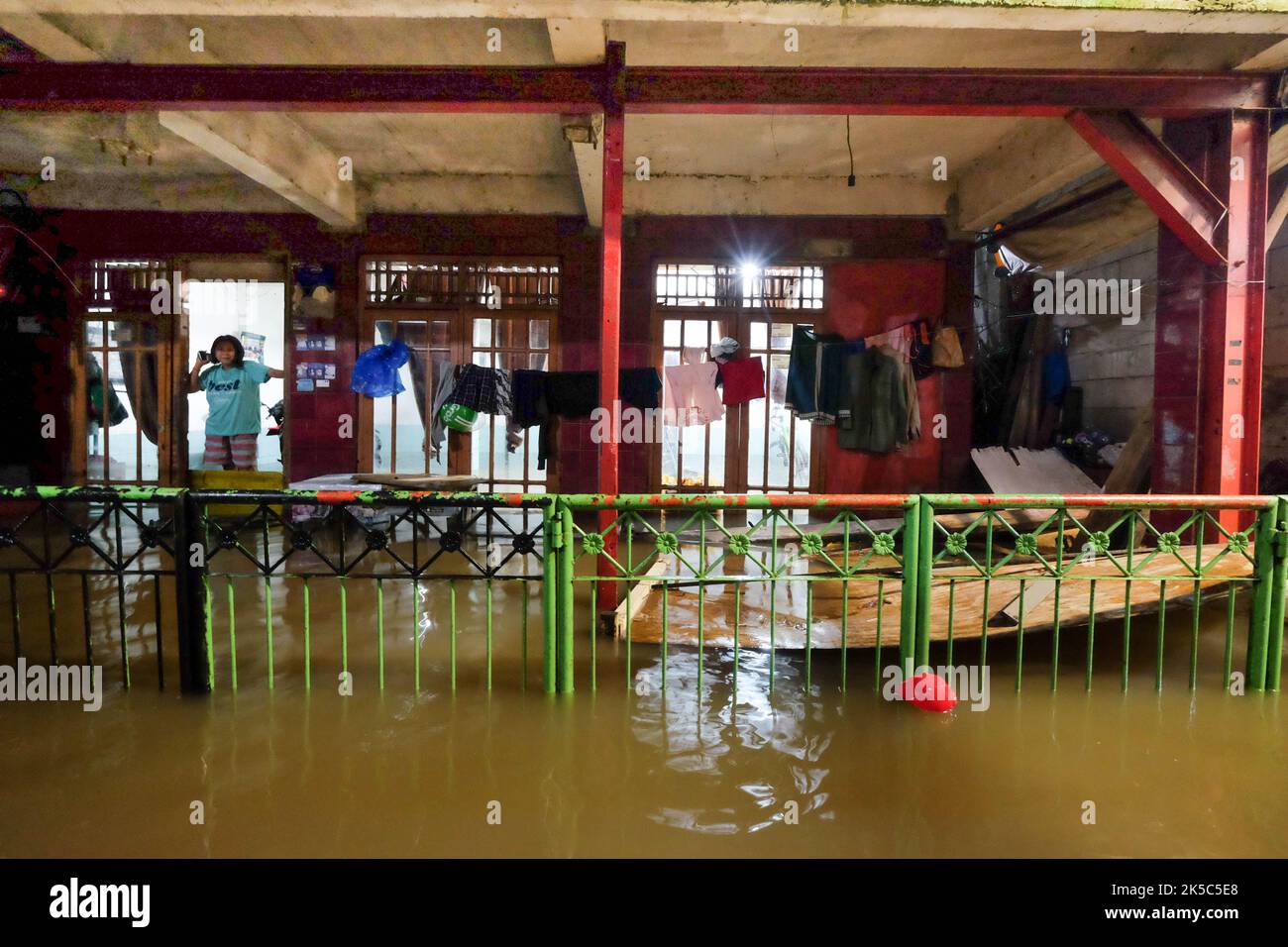 Residents stand in front of floodwaters after heavy rain, Thursday ...