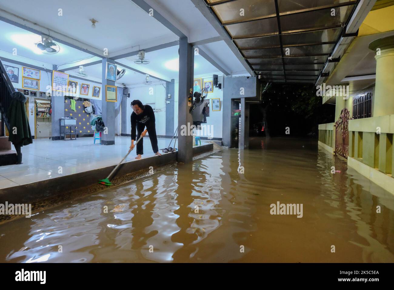 A man cleans trash during a flood after heavy rains, Thursday, October ...