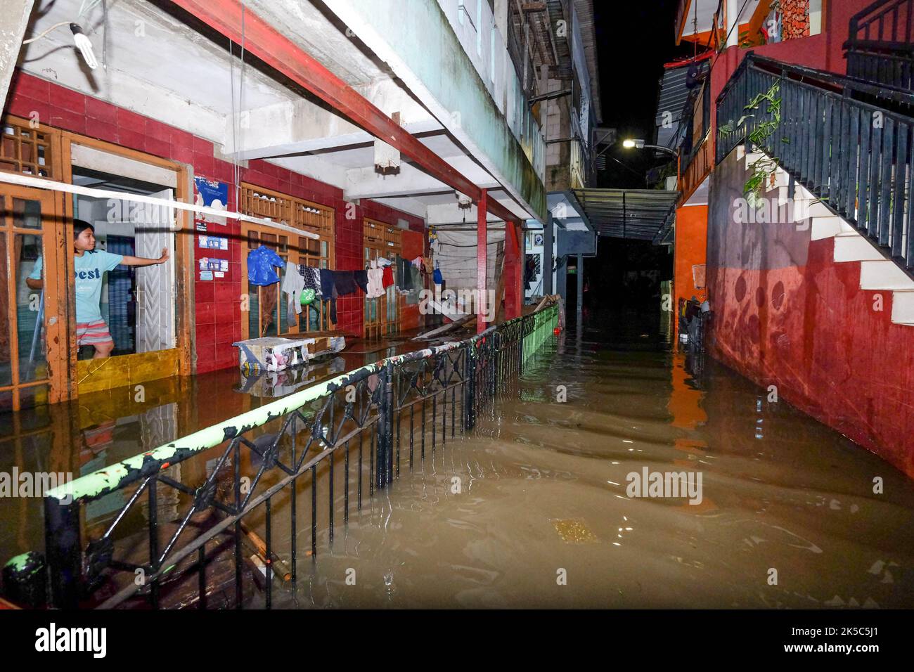 Residents stand in front of floodwaters after heavy rain, Thursday ...