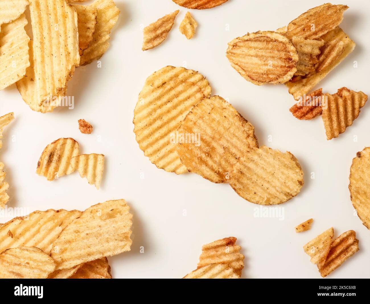 Clean background crinkle cut potato crisps in close up, food snack ...