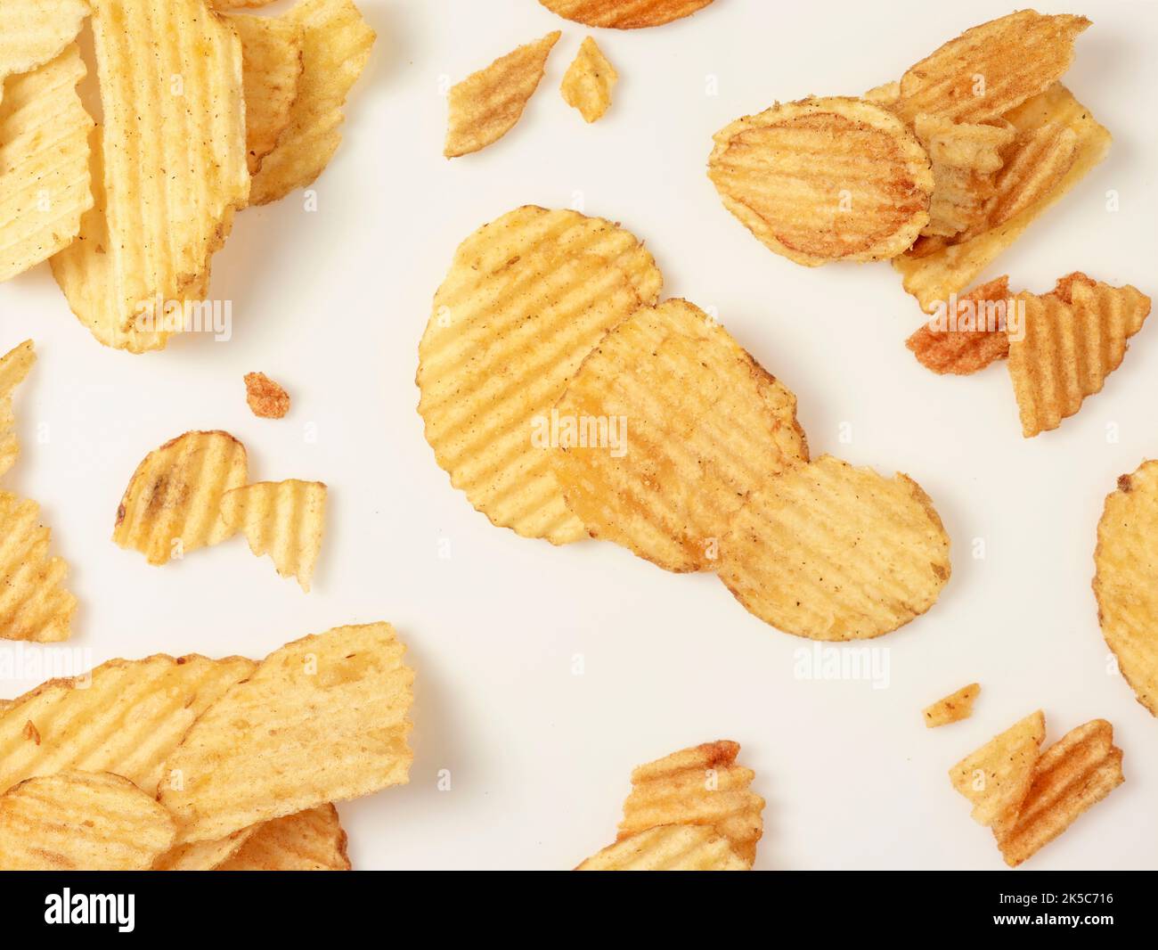 Clean background crinkle cut potato crisps in close up, food snack ...
